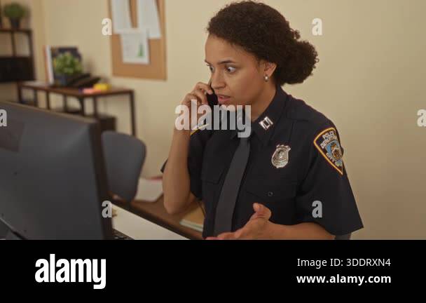 Woman officer in uniform talking on phone at police station desk ...