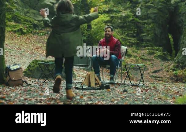Happy father and son speaking sitting in autumn woods. Child smiling ...