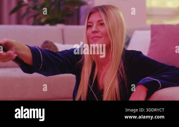 Happy attractive woman wearing pajama for home party alone watching TV ...