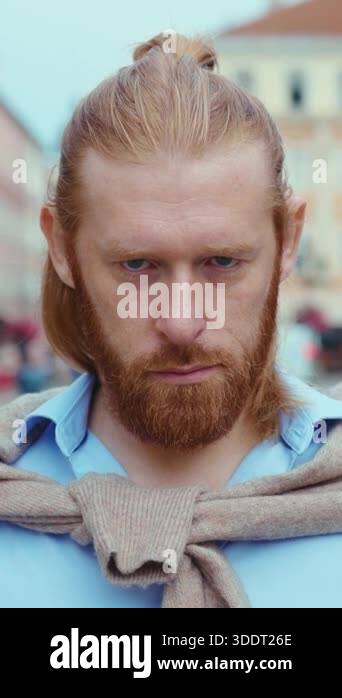 A thoughtful and contemplative man sporting a top knot hairstyle and ...