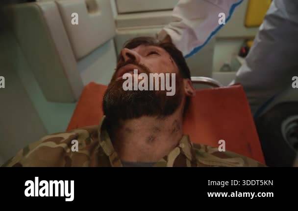 Close up hands medic provides medical care to a wounded military man ...