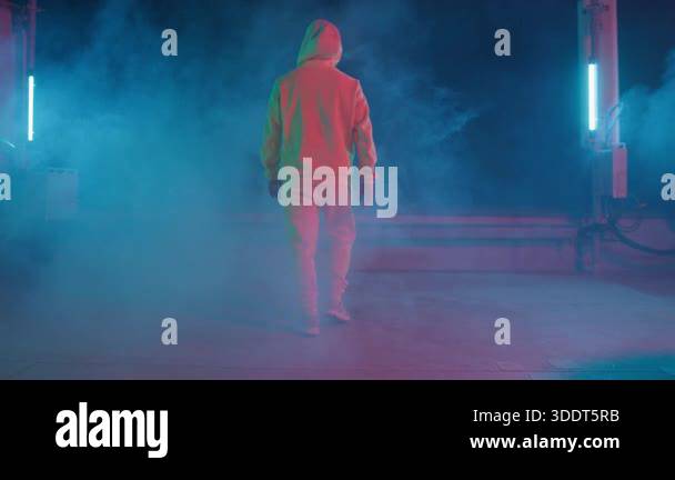 Night performance. Stylish man walking on smoked rooftop and watching ...