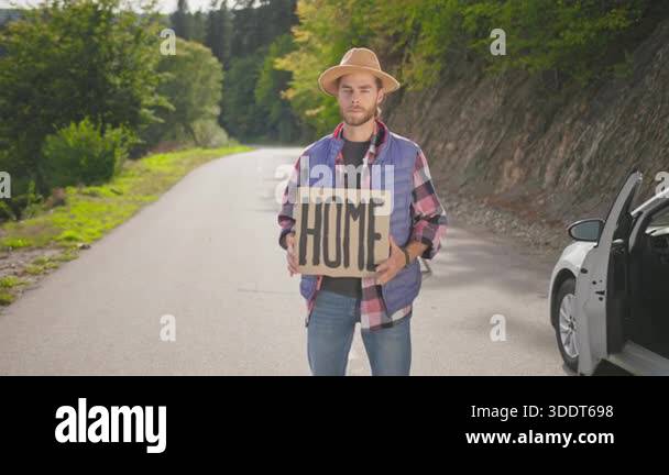 Portrait traveler sad caucasian man standing on roadside and holding ...