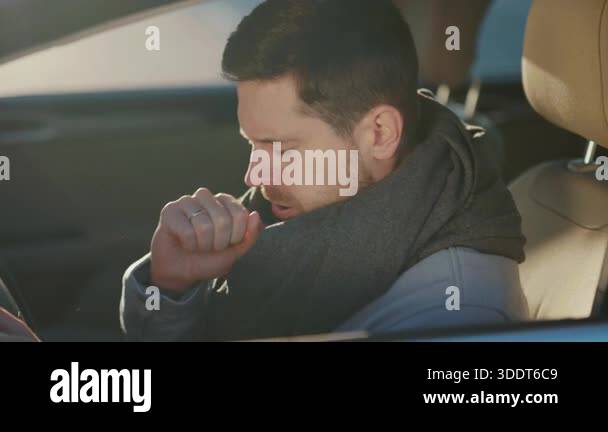 Caucasian unhealthy young man driving to work, coughing cold and ...