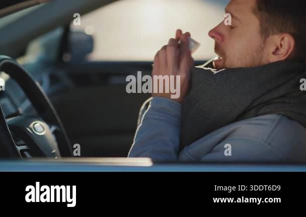 Caucasian sick young driver businessman sitting inside car sneezing ...