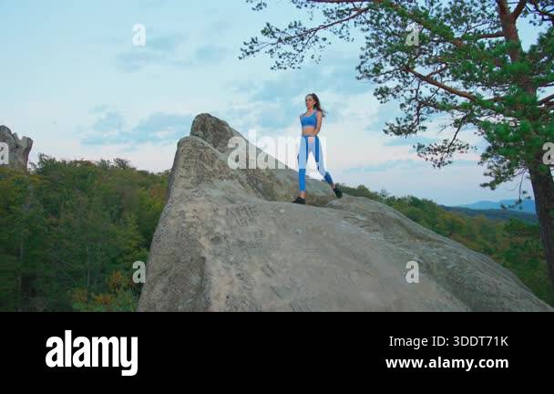 Beautiful slim athletic girl running on clifftop finishing hiking trail ...