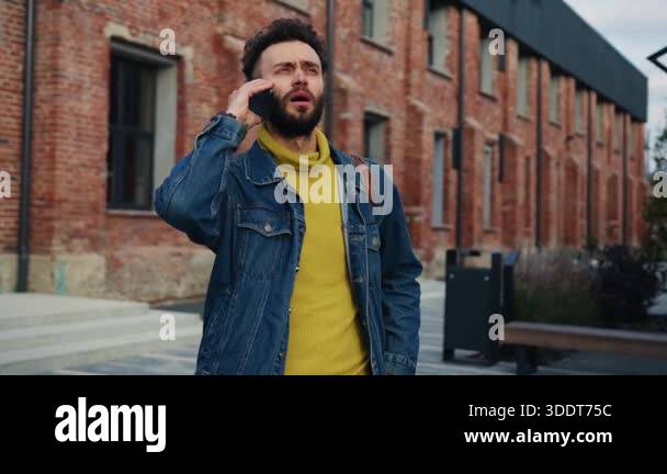 Portrait of young man lost in city. Handsome bearded guy holing ...