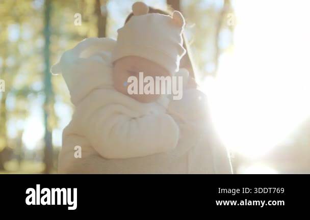 View from below of mother with lovely baby girl in white costume. Mom ...
