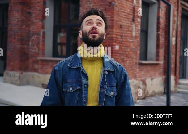 Portrait of upset young man raising hands to sky, screaming on city ...