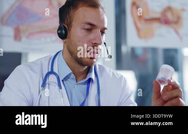 Handsome man doctor in white medical coat with headphones making ...