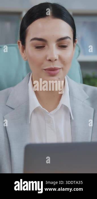 A professional woman dressed in a business suit is attentively ...