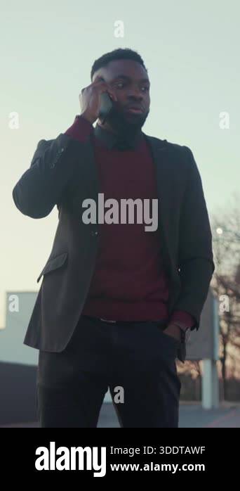 A professional man in a suit engages in a focused phone call, exuding ...