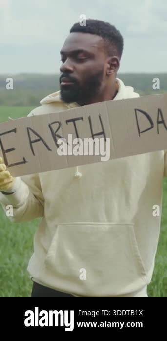 A passionate activist in nature, proudly holding an Earth Day sign to ...