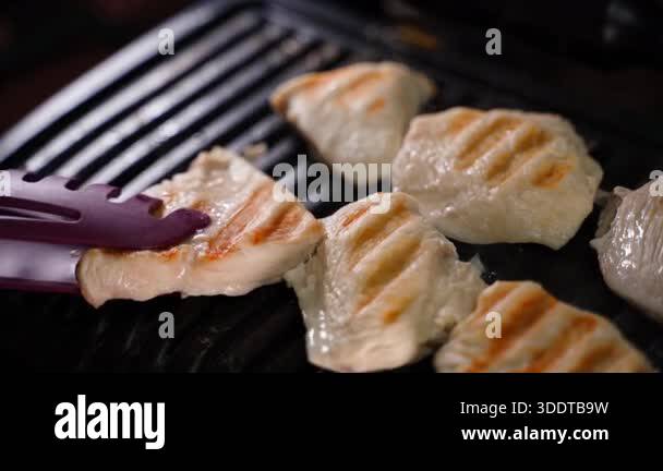 Cooked chicken fillet being removed from electric grill, close-up. High ...