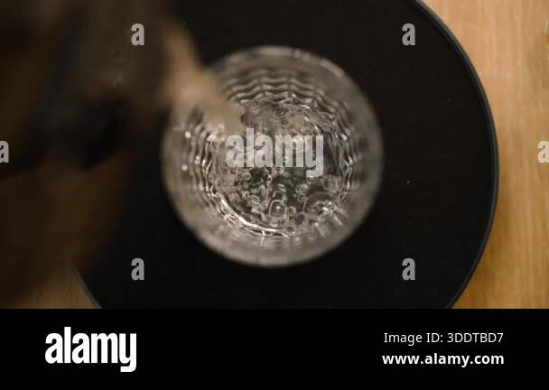 Top view of pouring water from a carafe into a glass, slow motion. High ...