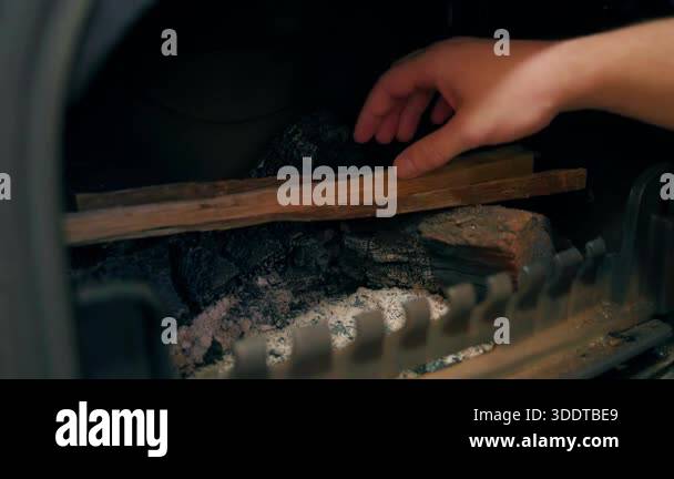 Laying firewood in the fireplace to start a fire, close-up. High ...