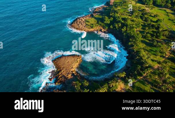 Foamy waves move to the cozy bay with sandy beach. Beautiful coast with ...