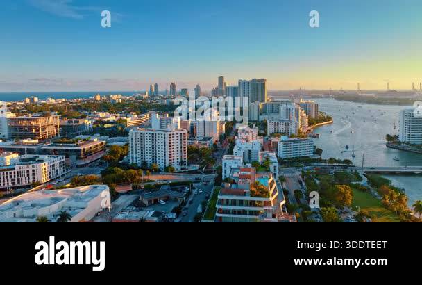Gorgeous cityscape of Miami lit with setting sun. Blue ocean waterscape ...