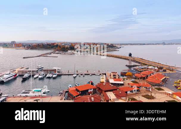 Flight over the red-roofed houses, berth with the boats and grey ...