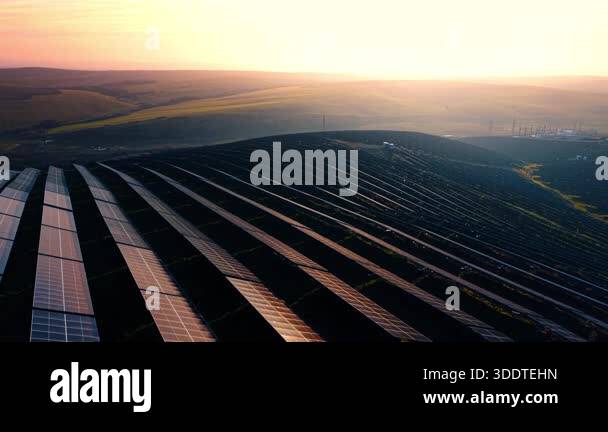 Rising over the hilly fields of modern solar panels. Setting sun ...