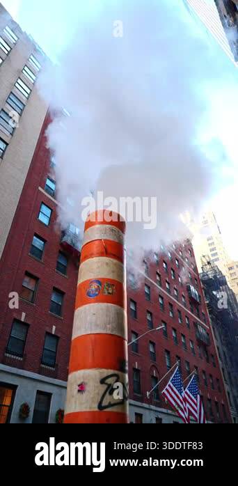 Red and white striped pipe emits the vapor or white smoke. Low angle ...