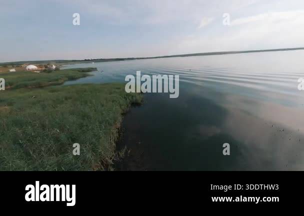 FPV aerial drone in beautiful scenic countryside. Peaceful river flat ...