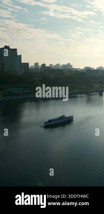 White passenger ferry boat navigating calm river under cloudy sky. Clip ...