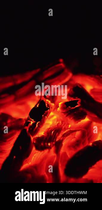 Pieces of burnt out wood smoldering in a pile. Close up view of the ...