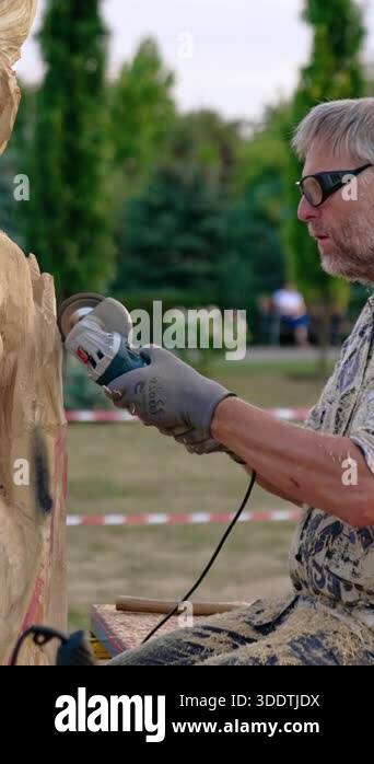 Craftsman professional worker. Artist making wooden sculpture. Vertical ...