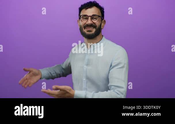 Hispanic man with beard smiling and gesturing towards purple background ...