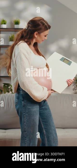 Pregnant woman holding scale, monitoring weight gain during pregnancy ...