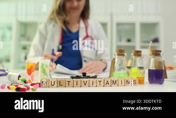 Wooden cubes spell word Multivitamins near colorful pills and juice ...