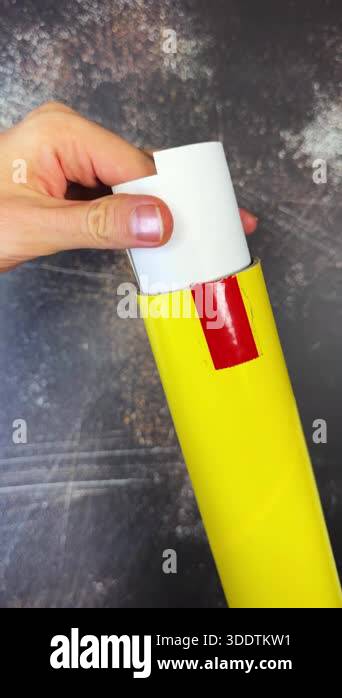 Female hands holding yellow tube with a paper inside. Person takes the ...