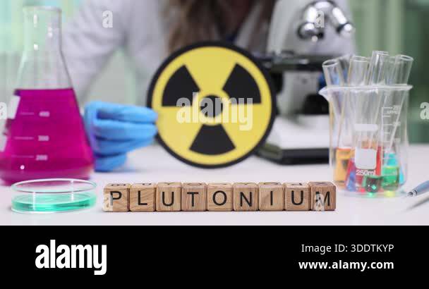 Laboratory worker shows warning sign indicating radiation danger ...