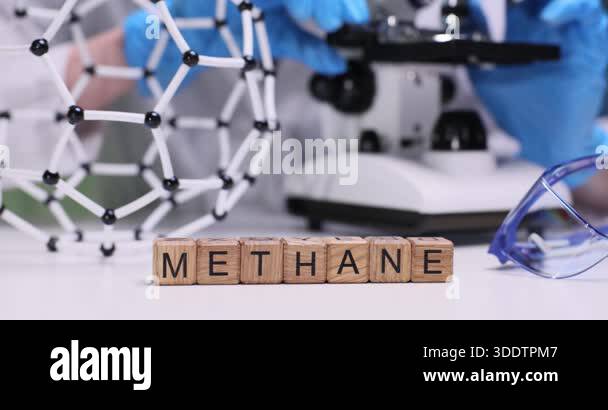 Laboratory worker uses microscope to examine sample portraying methane ...