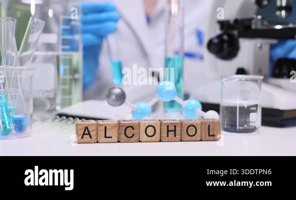 Worker tilts test tube slightly to observe viscosity of alcohol-based ...