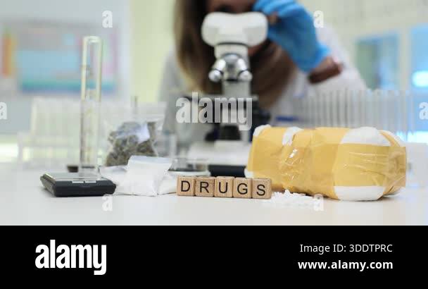Wooden cubes spell word Drugs in front of powder wrapped package and ...