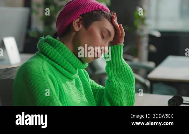 Transgender person suffering from headache while working on laptop in ...