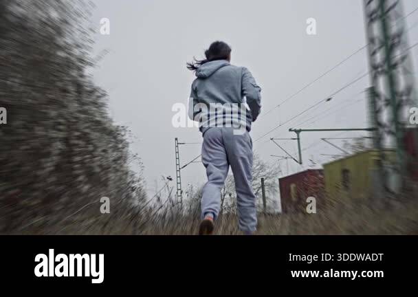 Person In Hoodie Moves Across Landscape, Individual With Hoodie Runs ...