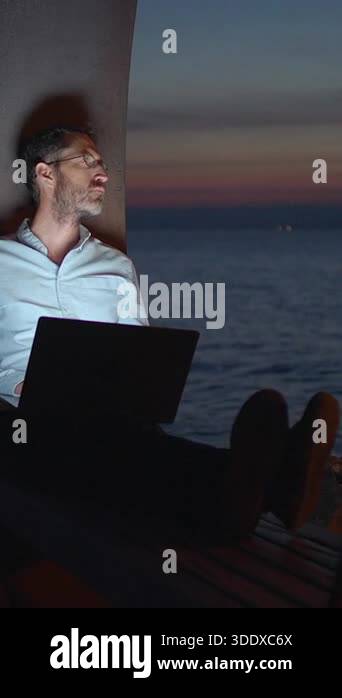 A man is absorbed in using his laptop while savoring the peaceful ...