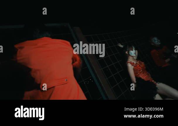 A dynamic, shaky-cam shot of a male performer in gothic clown makeup ...