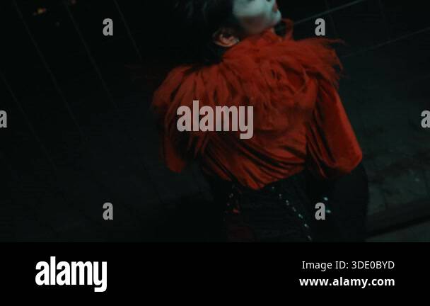 A dynamic, disorienting close-up of a male performer in gothic clown ...