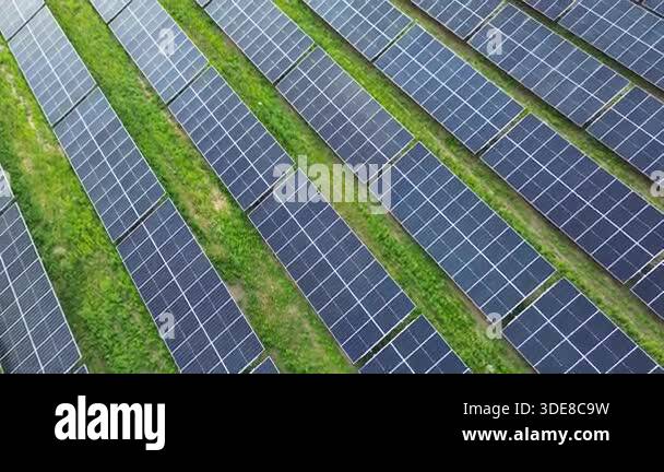 Solar panels in green field at sunrise Stock Video Footage - Alamy