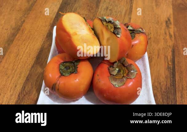 fresh persimmon fruit cut open showing bright orange flesh Stock Video ...