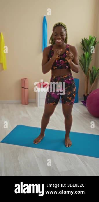 Woman dancing in gym with colorful outfit, smiling happily on exercise ...
