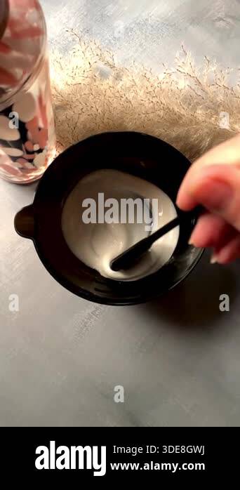 Close-up of hair dye mixture in a black bowl with professional coloring ...