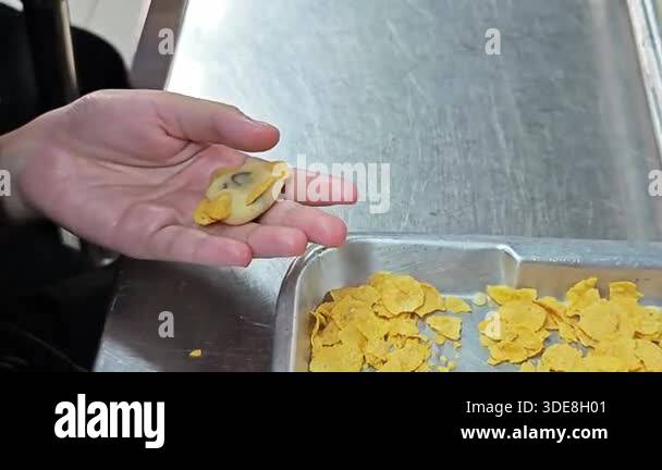Hand-shaping homemade cornflake cookies in a bakery-style setting ...