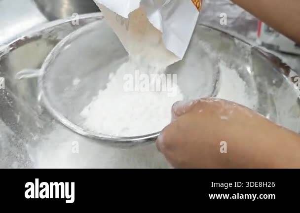 Using a flour sifter to strain flour, highlighting an essential step in ...
