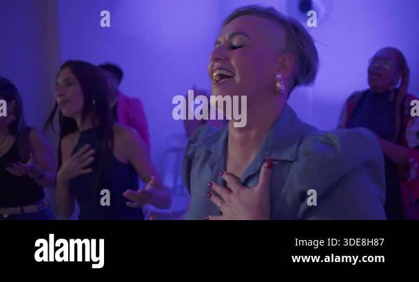 Joyful woman with hand on chest worships alongside others in ...