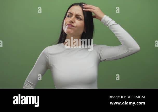 Hispanic woman in white shirt scratching head with thoughtful ...